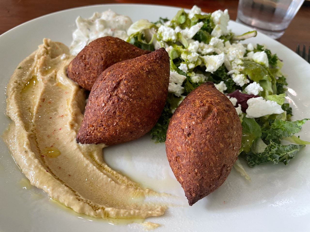 Kibbeh with lemon hummus, Tzatziki sauce, crunchy kale slaw with an ...